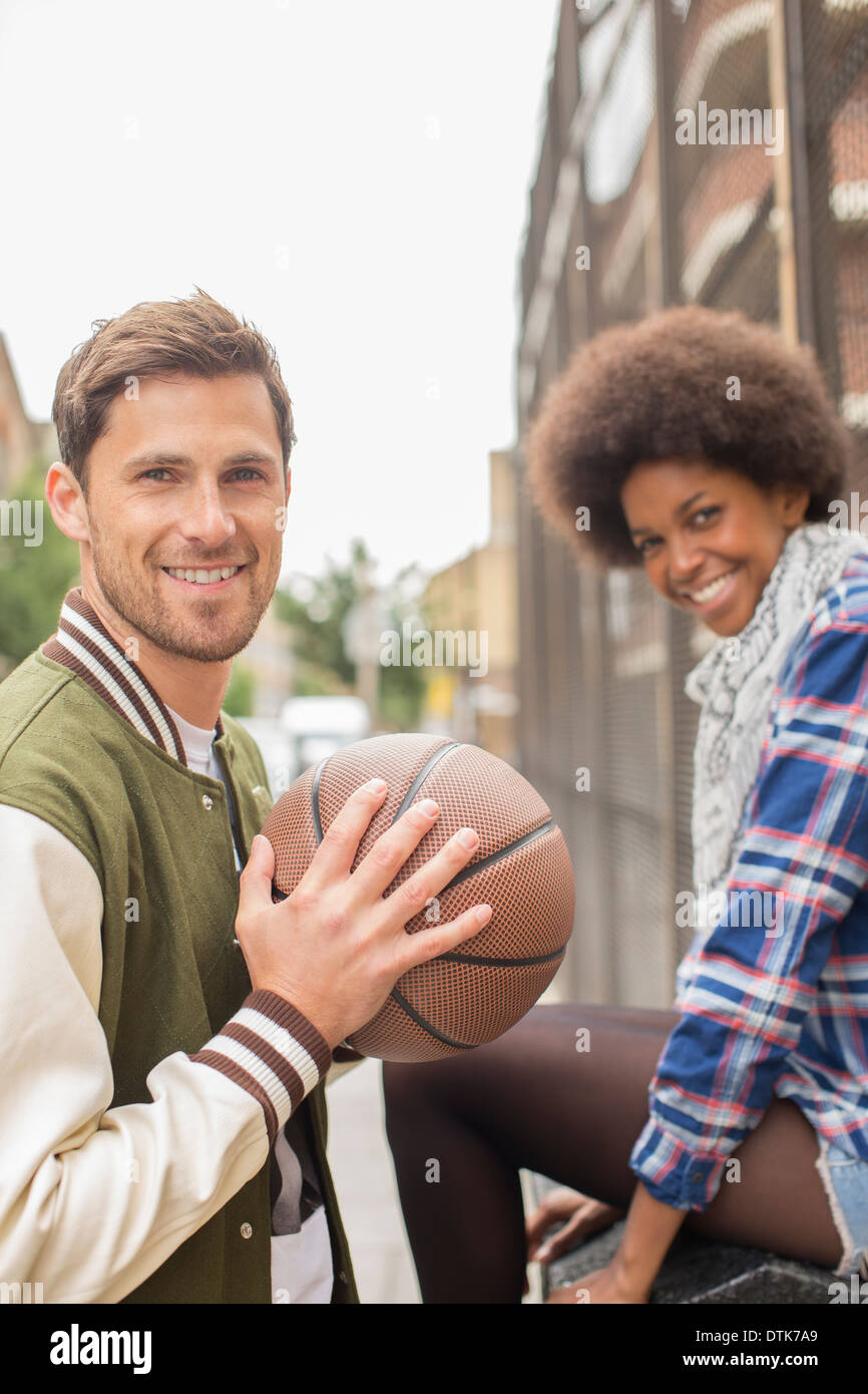 Couple smiling together on city street Stock Photo - Alamy