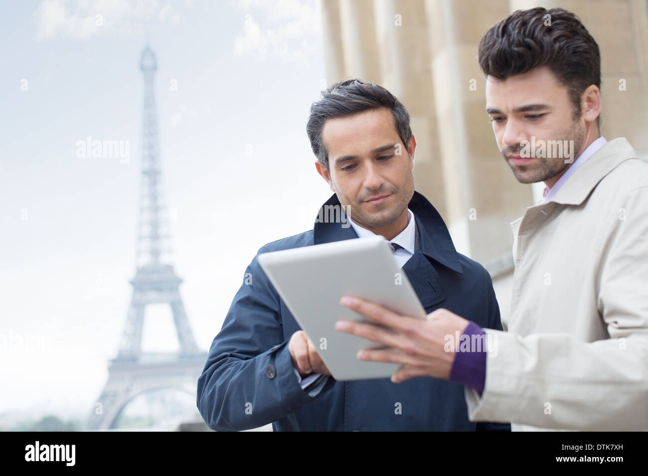 Businessmen using digital tablet near Eiffel Tower, Paris, France Stock ...