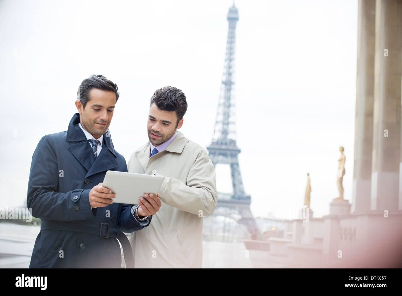 Businessmen using digital tablet near Eiffel Tower, Paris, France Stock ...