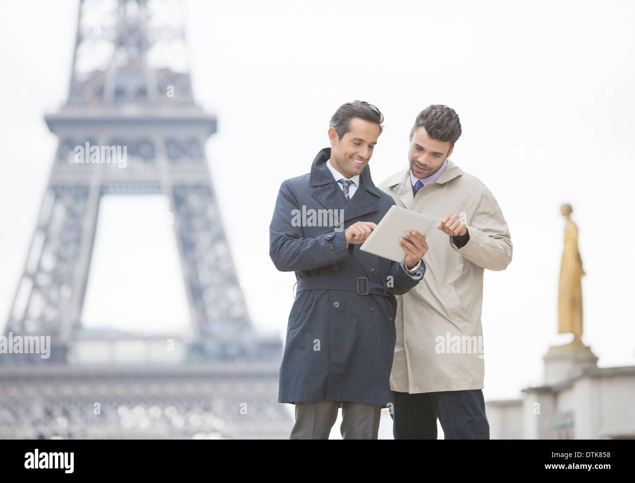 Businessmen using digital tablet near Eiffel Tower, Paris, France Stock ...