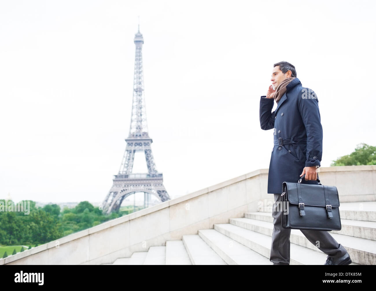 Businessmen on cell phone on steps near Eiffel Tower, Paris, France ...