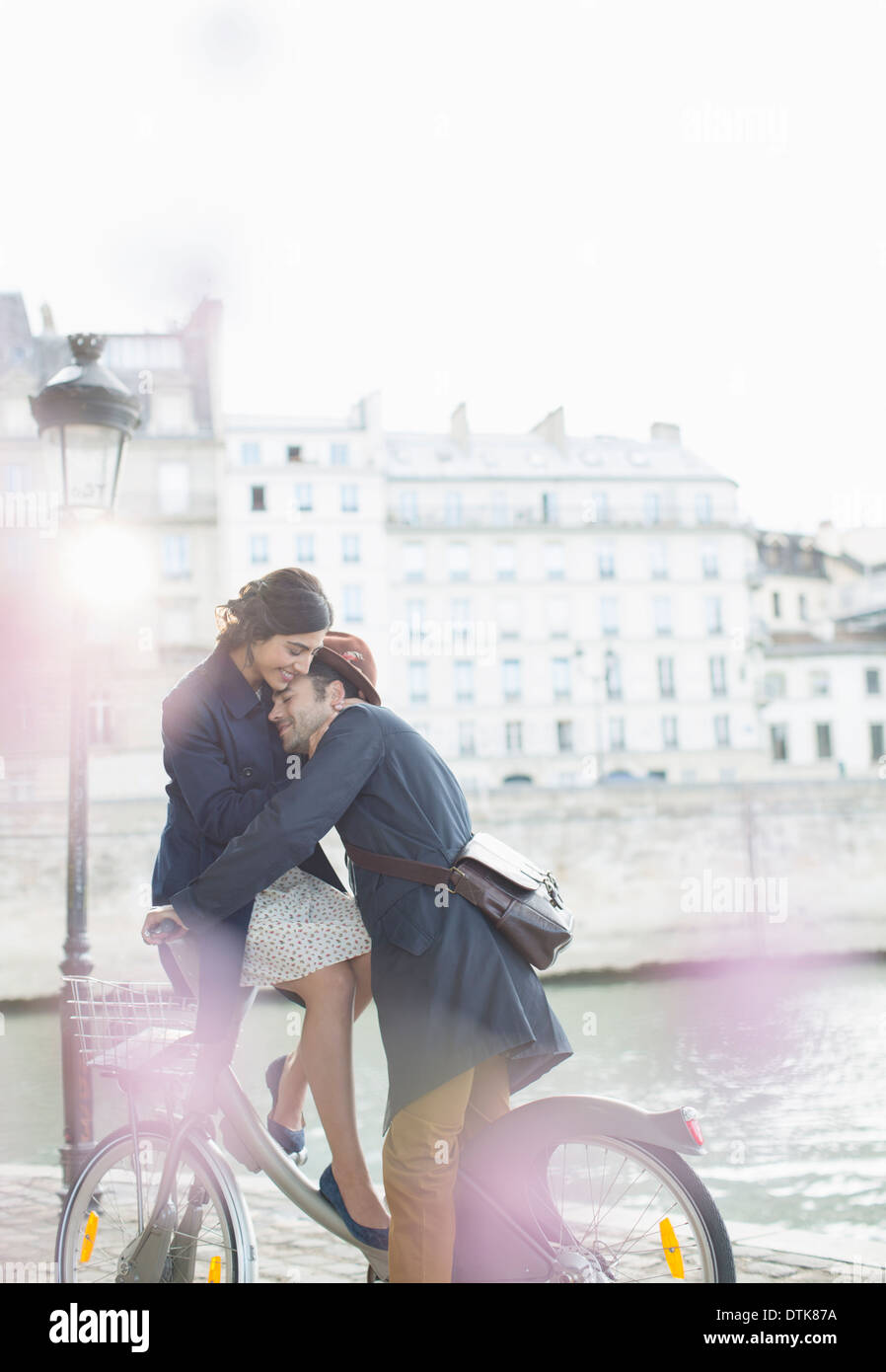 Couple hugging on bicycle along Seine River, Paris, France Stock Photo ...