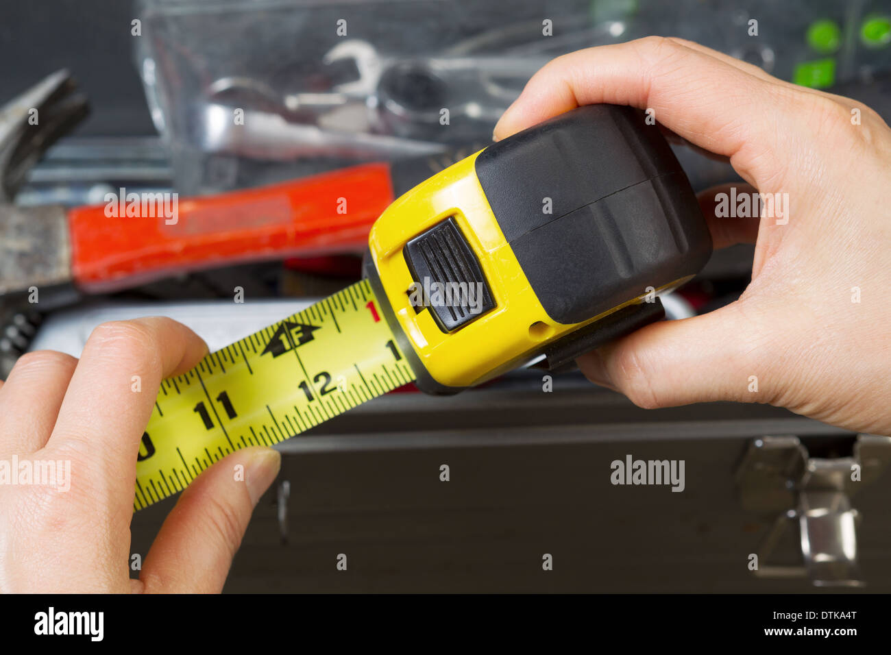 Horizontal photo of female hands pulling used tape measure out with old ...