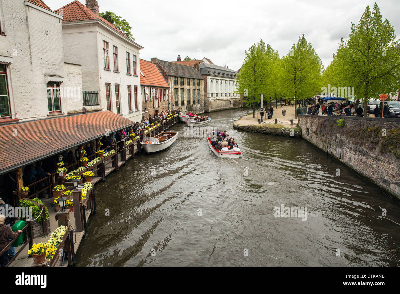 Tourists enjoying a boat ride around the canals of Bruges in Belgium ...