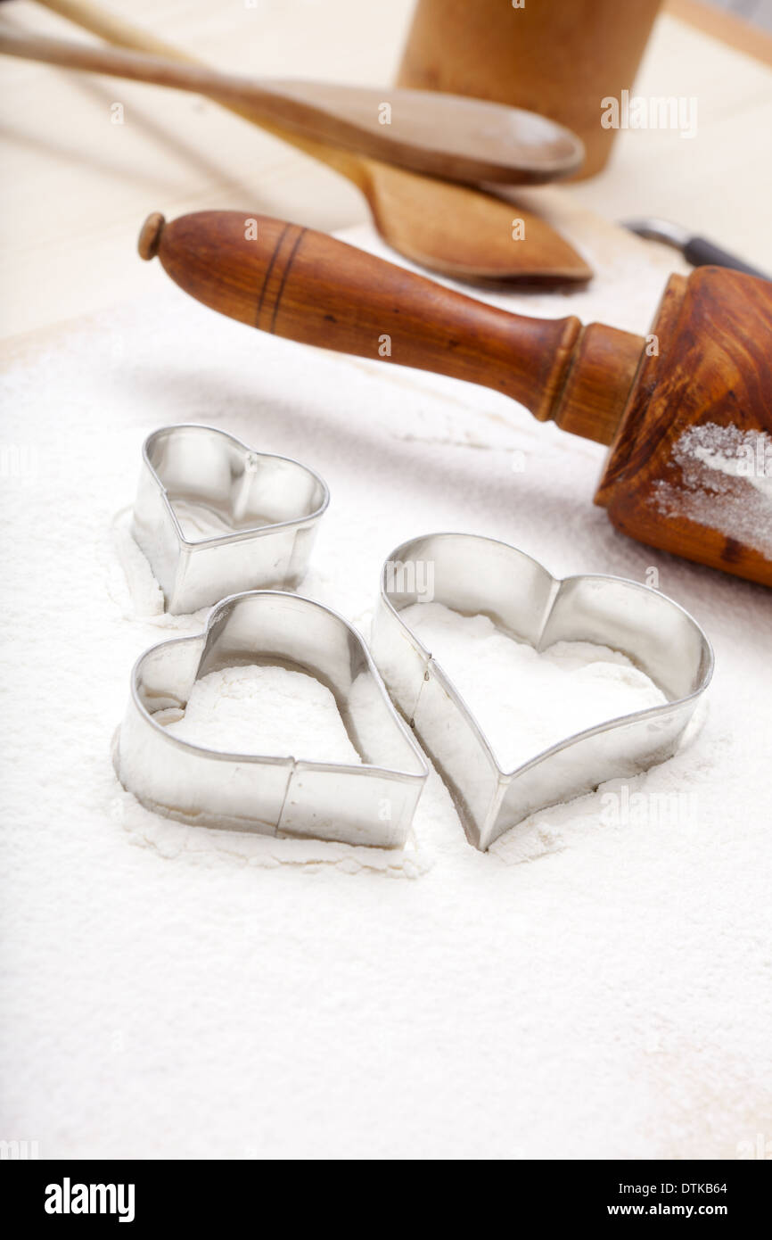Cookie cutter in heart shape, rolling pin and wooden spoon on white ...