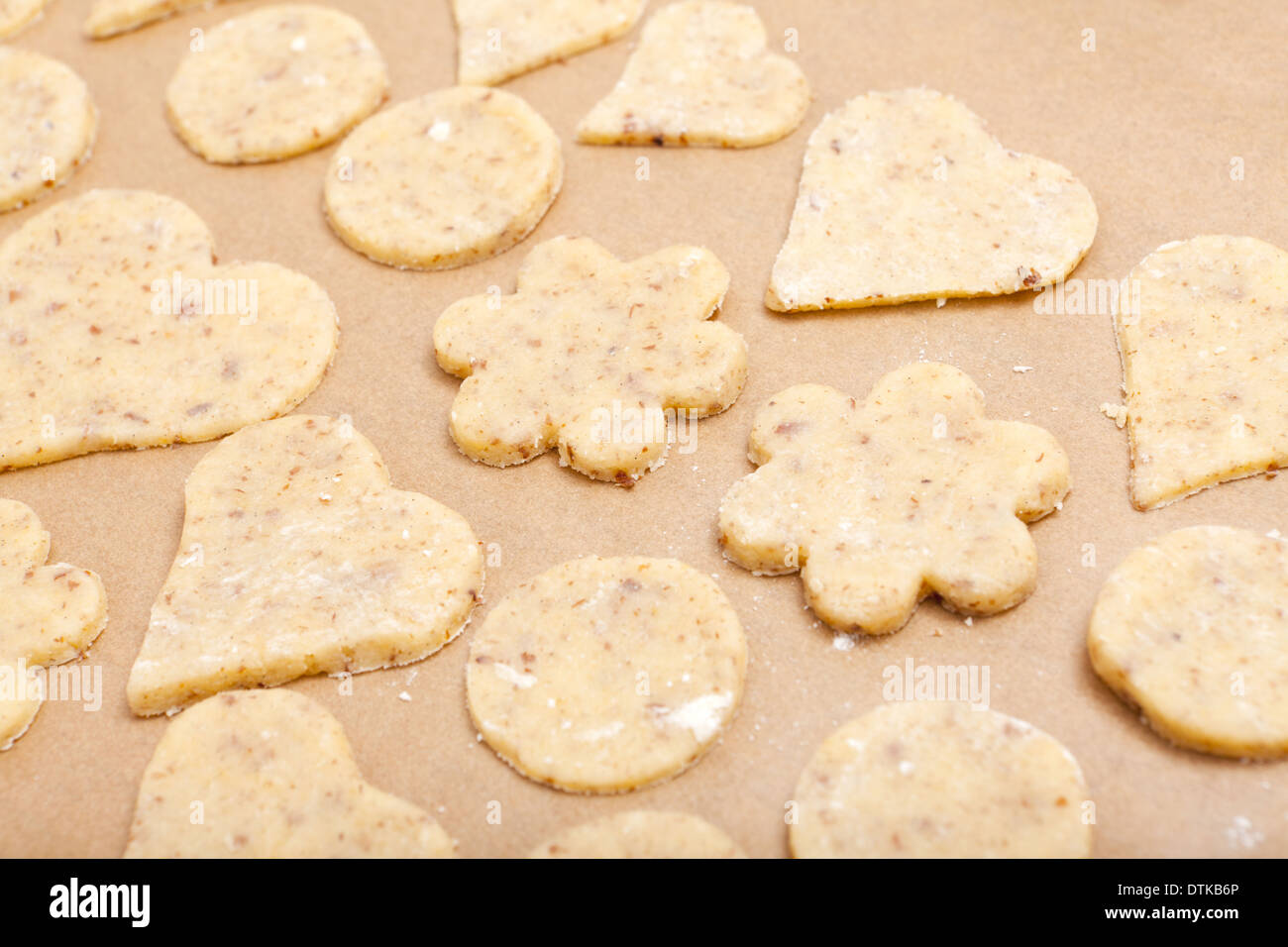 Cookie dough in different shapes on a baking sheet with parchment paper ...