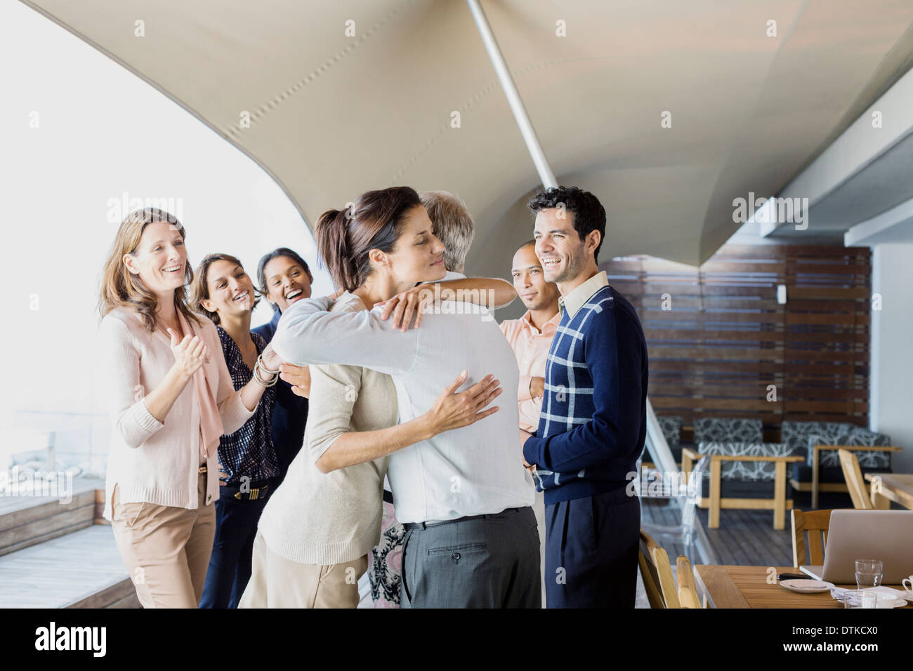 Business people hugging in office Stock Photo - Alamy