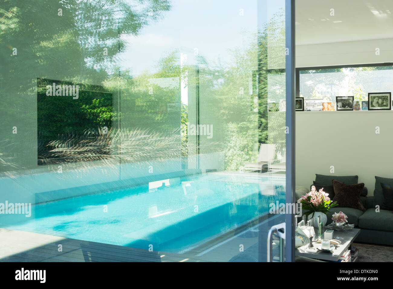 Swimming pool reflected in glass windows of modern house Stock Photo ...
