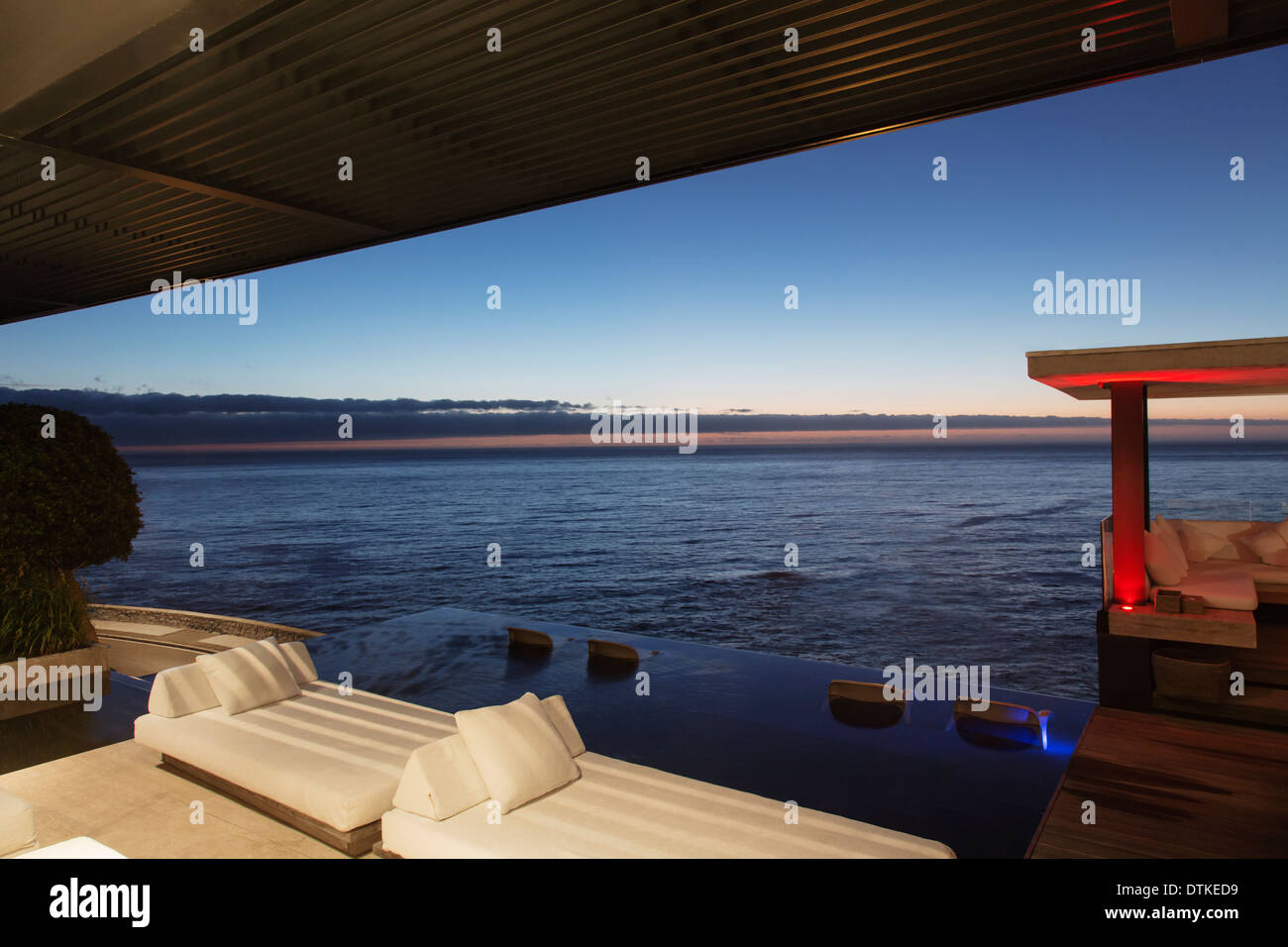 Sofas and infinity pool overlooking ocean Stock Photo - Alamy