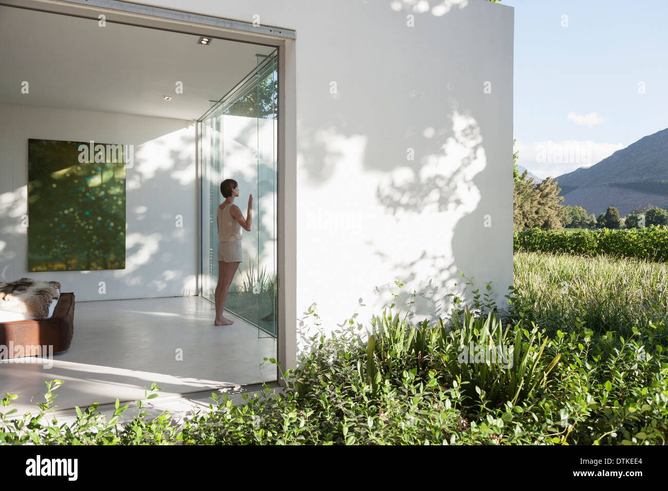 Woman standing at window in modern house Stock Photo - Alamy