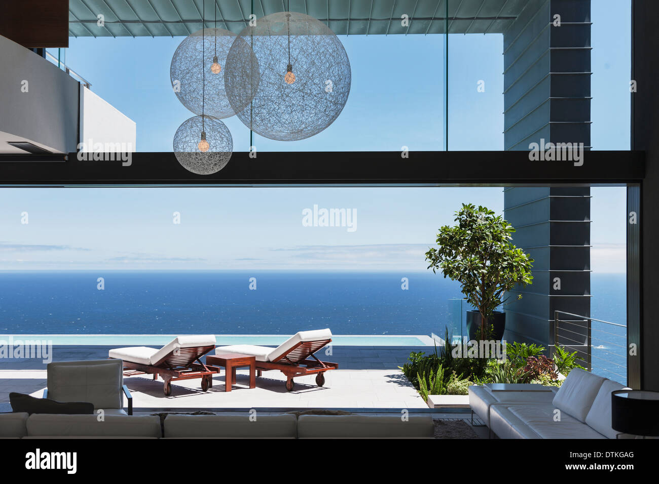 Lounge chairs on balcony overlooking ocean Stock Photo - Alamy