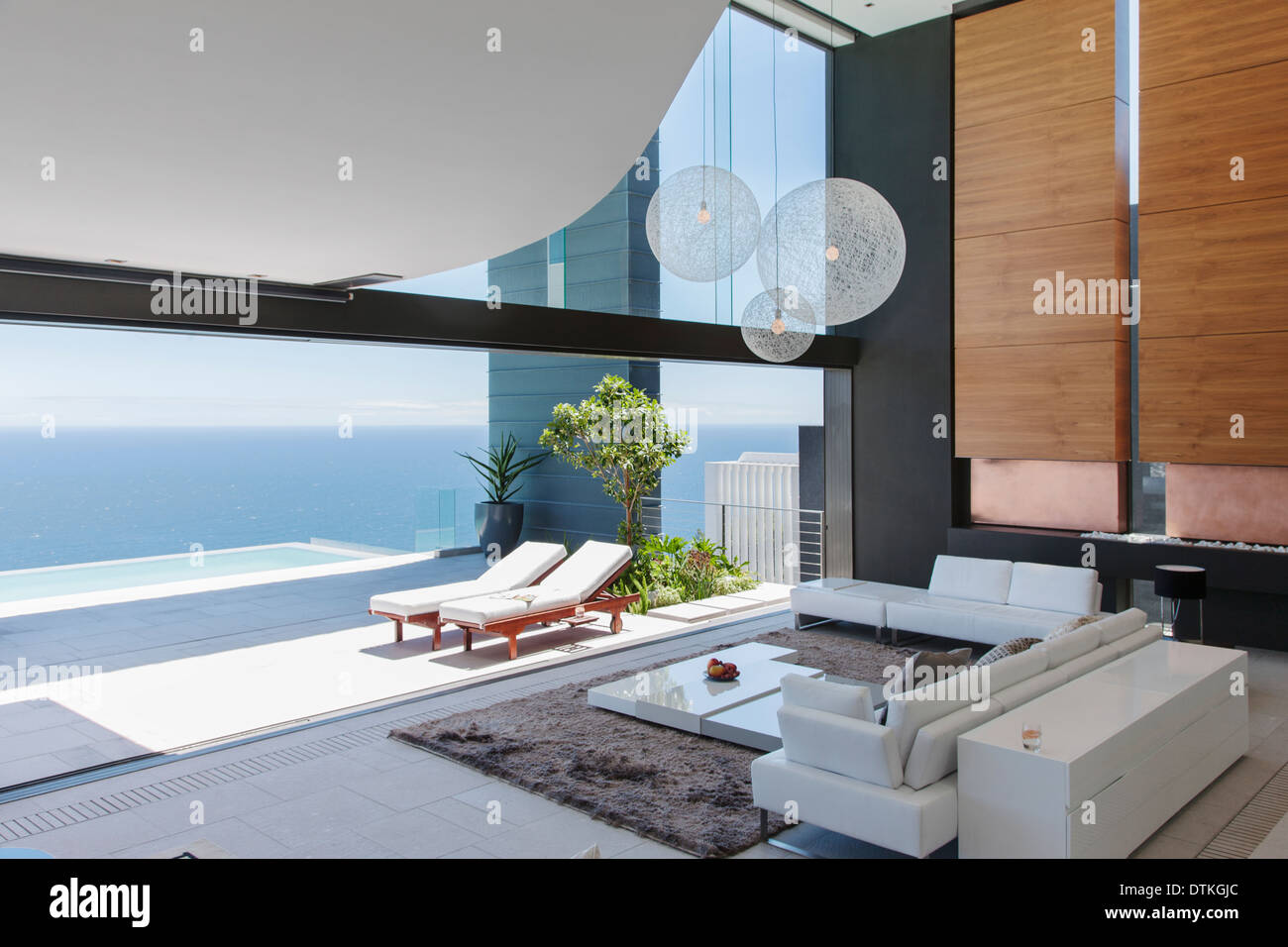 Living room and patio of modern house overlooking ocean Stock Photo - Alamy