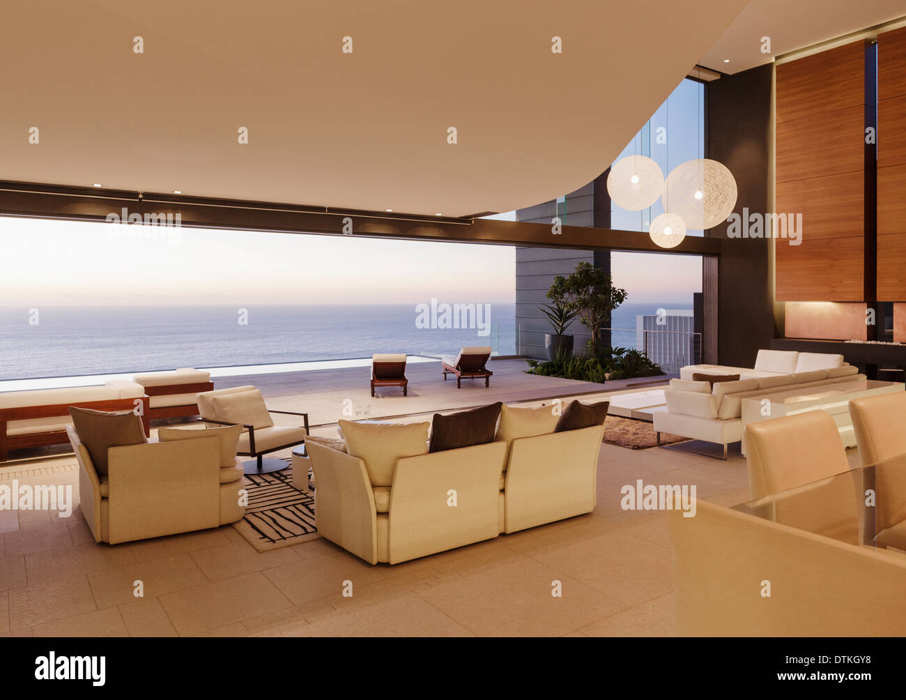 Living room in modern house overlooking ocean at sunset Stock Photo - Alamy