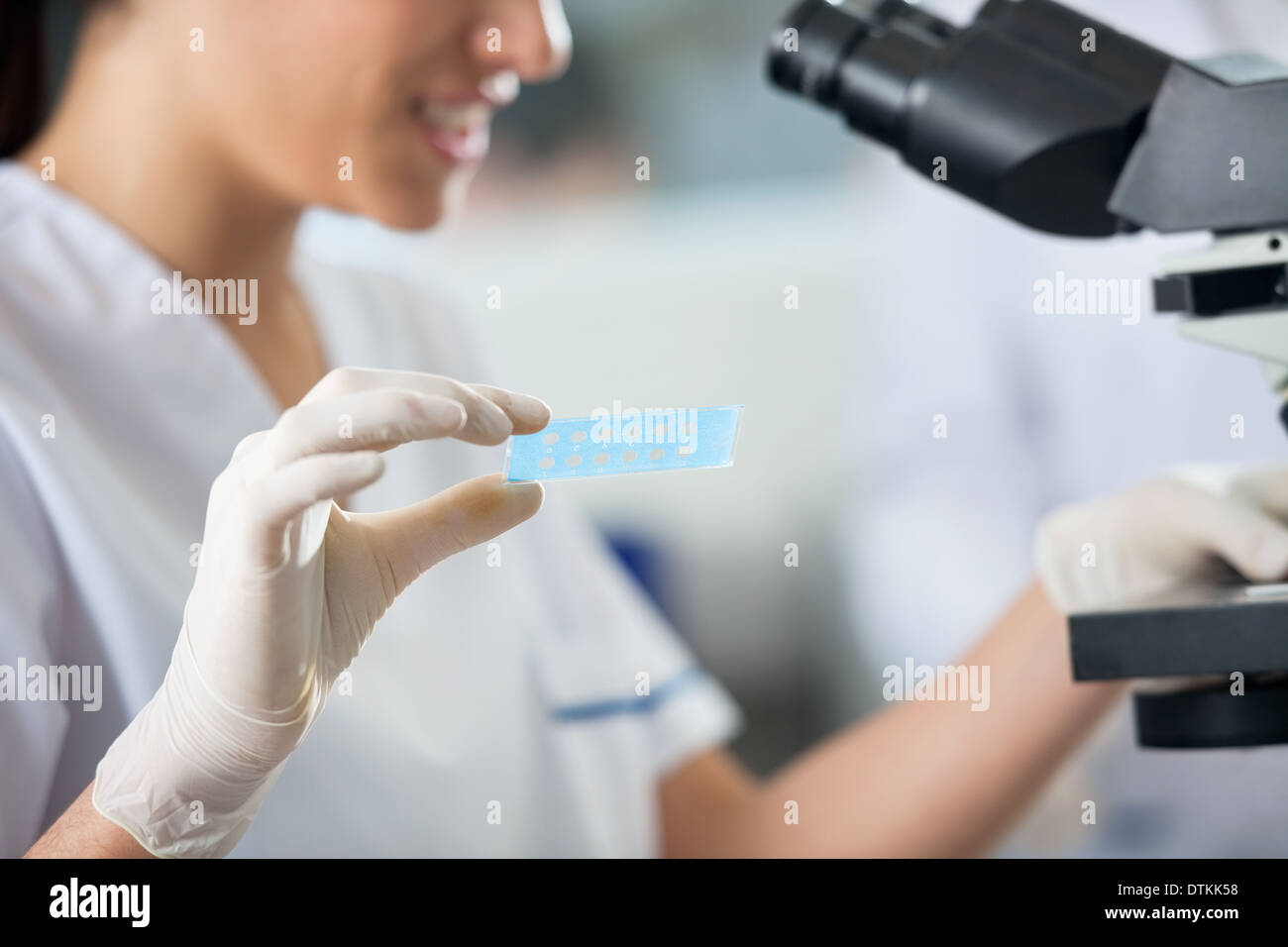 Researcher Holding Slide While Using Microscope Stock Photo - Alamy