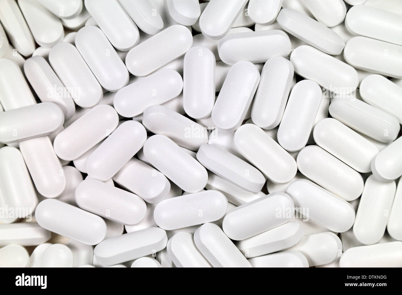 Pile of white capsule type pills on a light background Stock Photo - Alamy
