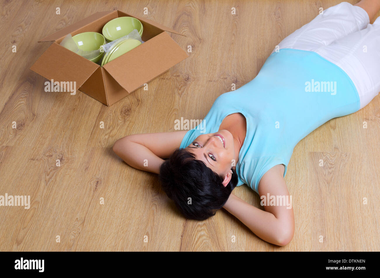 Laying woman and box with dishware Stock Photo - Alamy