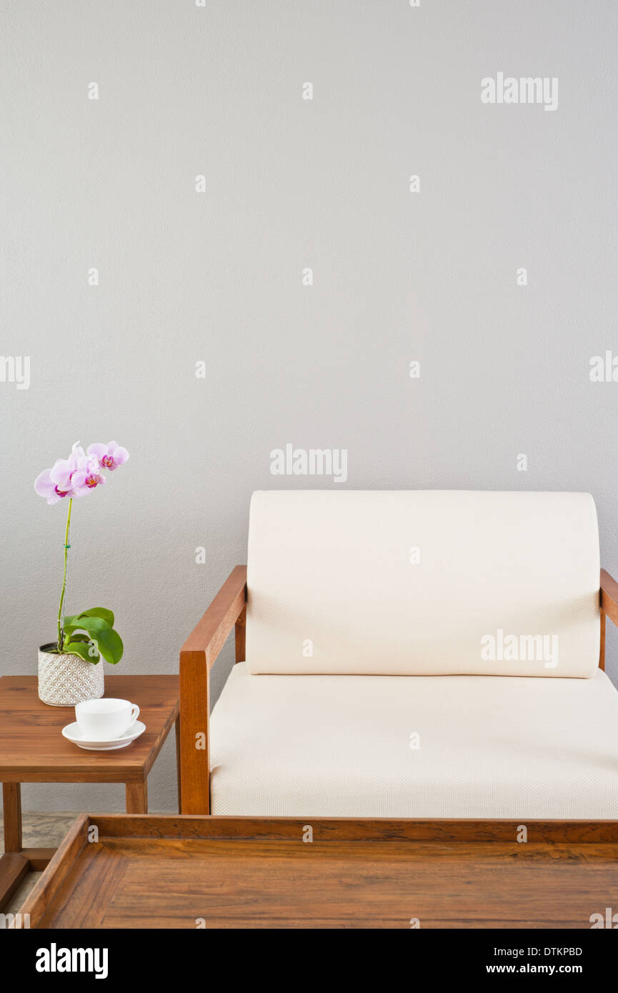 Bright white seater in lounge area and flowers Stock Photo - Alamy