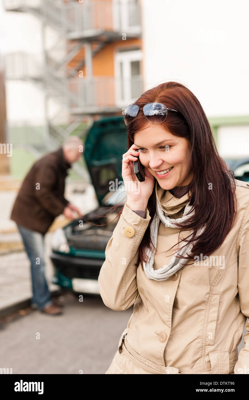 Woman on the phone repairman fixing car Stock Photo - Alamy