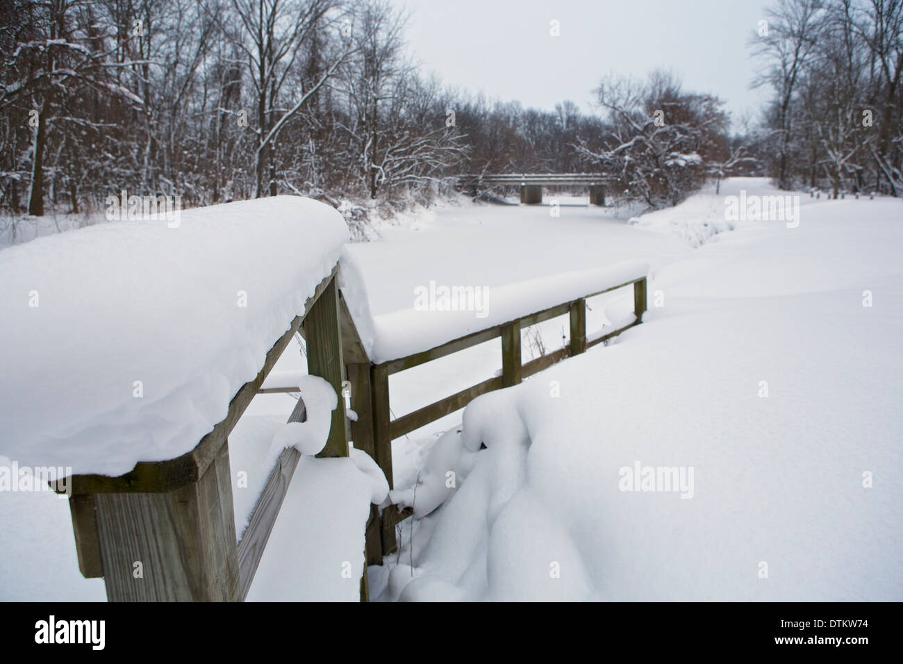 Snow covers a railing alongside the Black River / Macatawa River at Paw ...