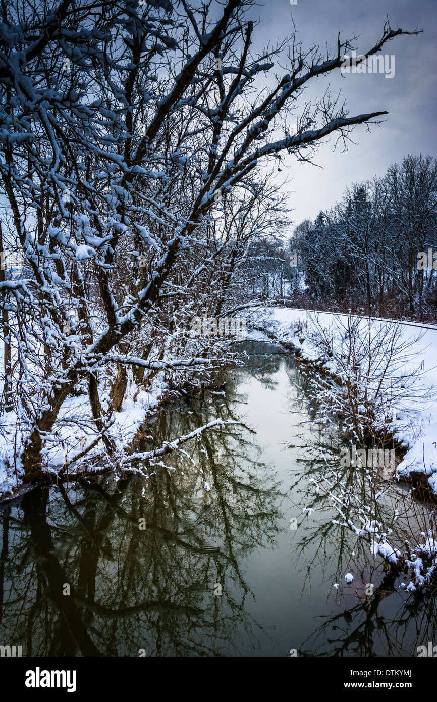 Snow covered trees reflecting in a creek in rural Carroll County ...