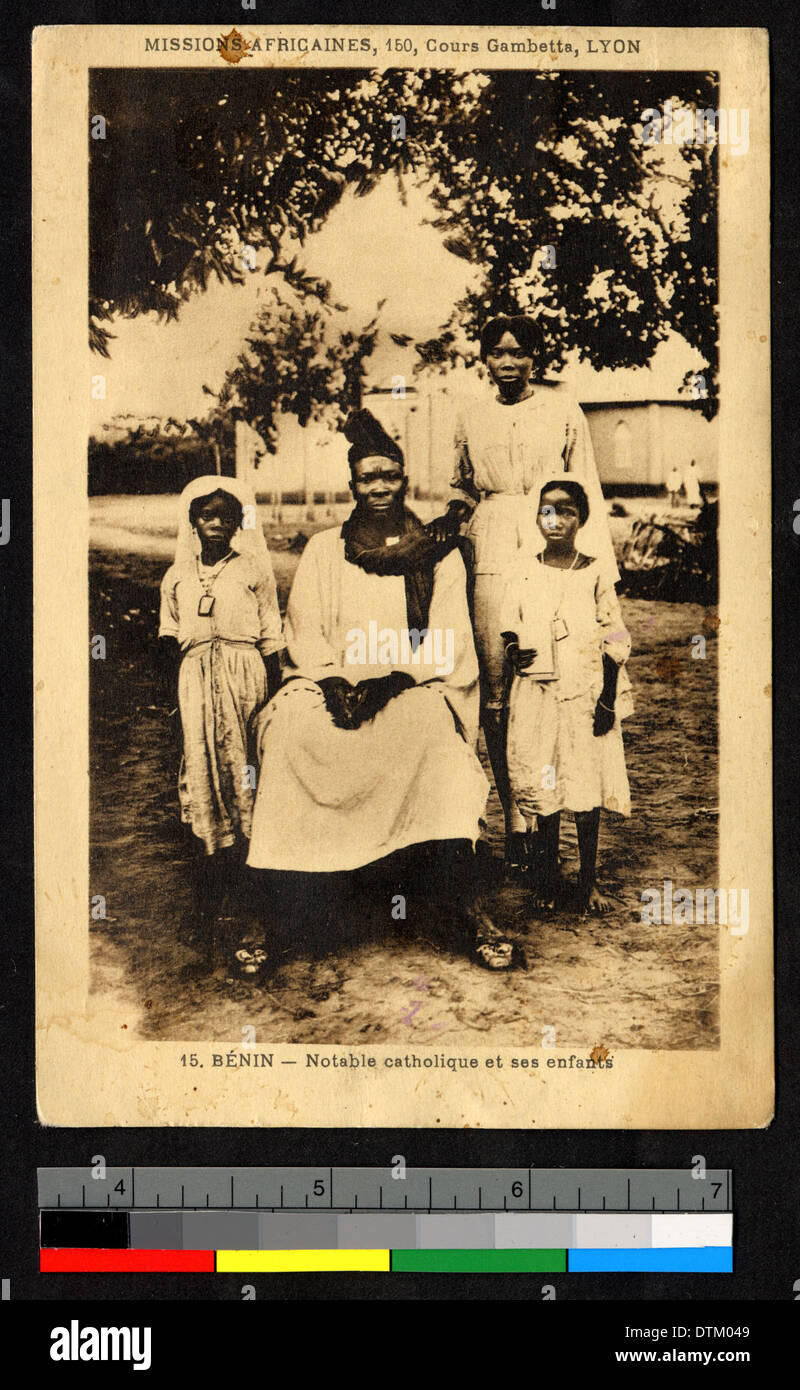 A man is seated surrounded by his family in Benin, captured in a ...