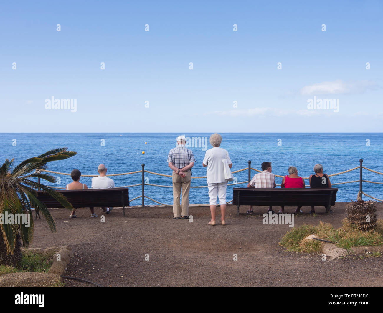 Strolling the coastal promenade, stops to rest and admire the views of ...