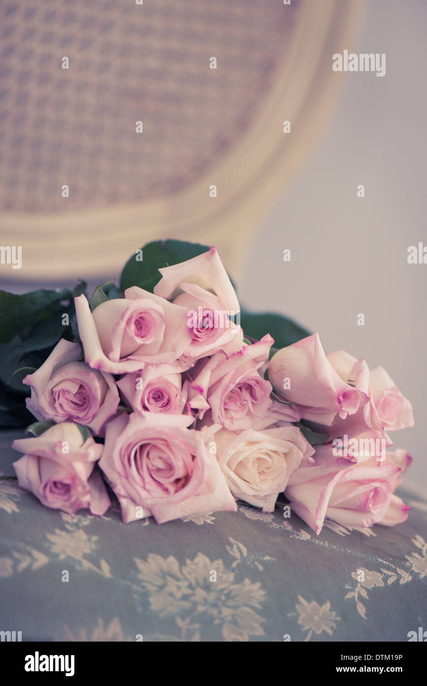 A dozen pink roses resting on a chair Stock Photo - Alamy