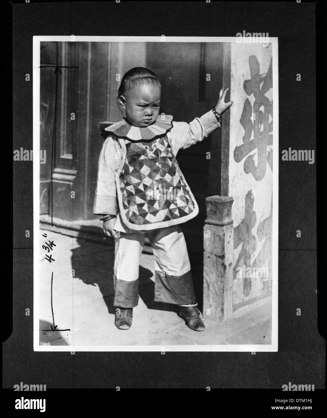 A small Chinese boy dressed in traditional clothing, photographed ...