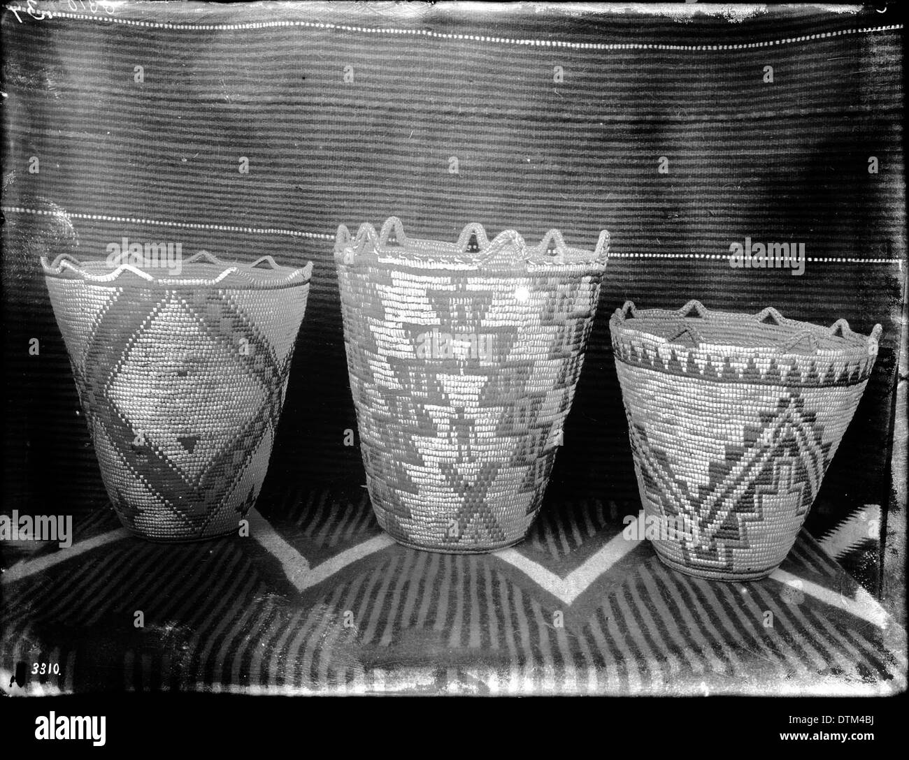 Three Indian baskets are displayed in a vintage photograph taken around ...