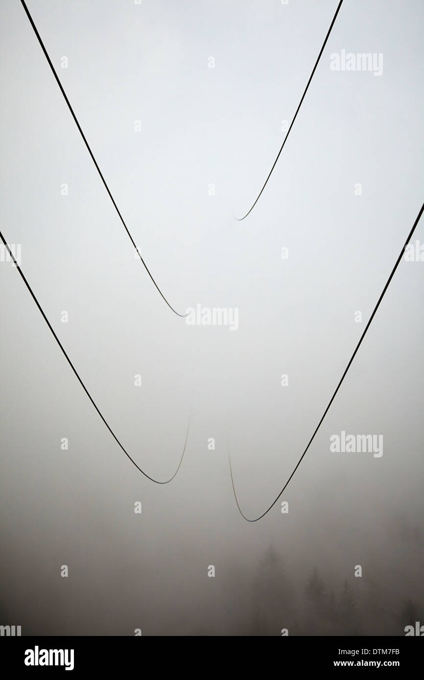 Cablecar, or telepherique, cables disappearing into the mist from ...