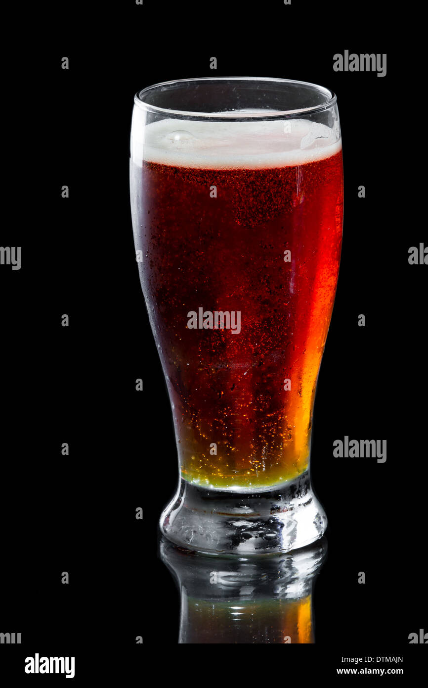cold refreshing beer served in a cold glass isolated on a black ...