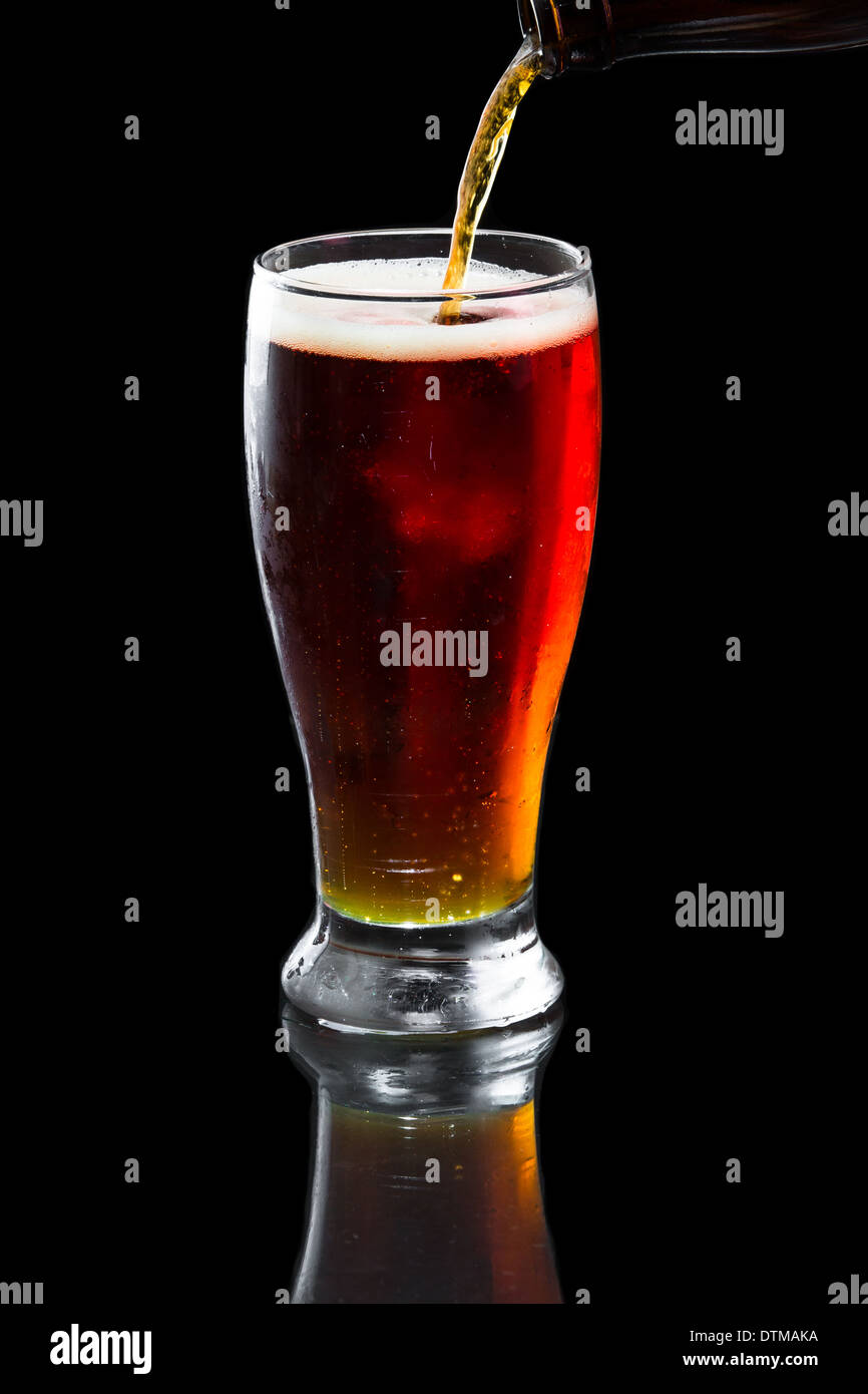 cold refreshing beer served in a cold glass isolated on a black ...