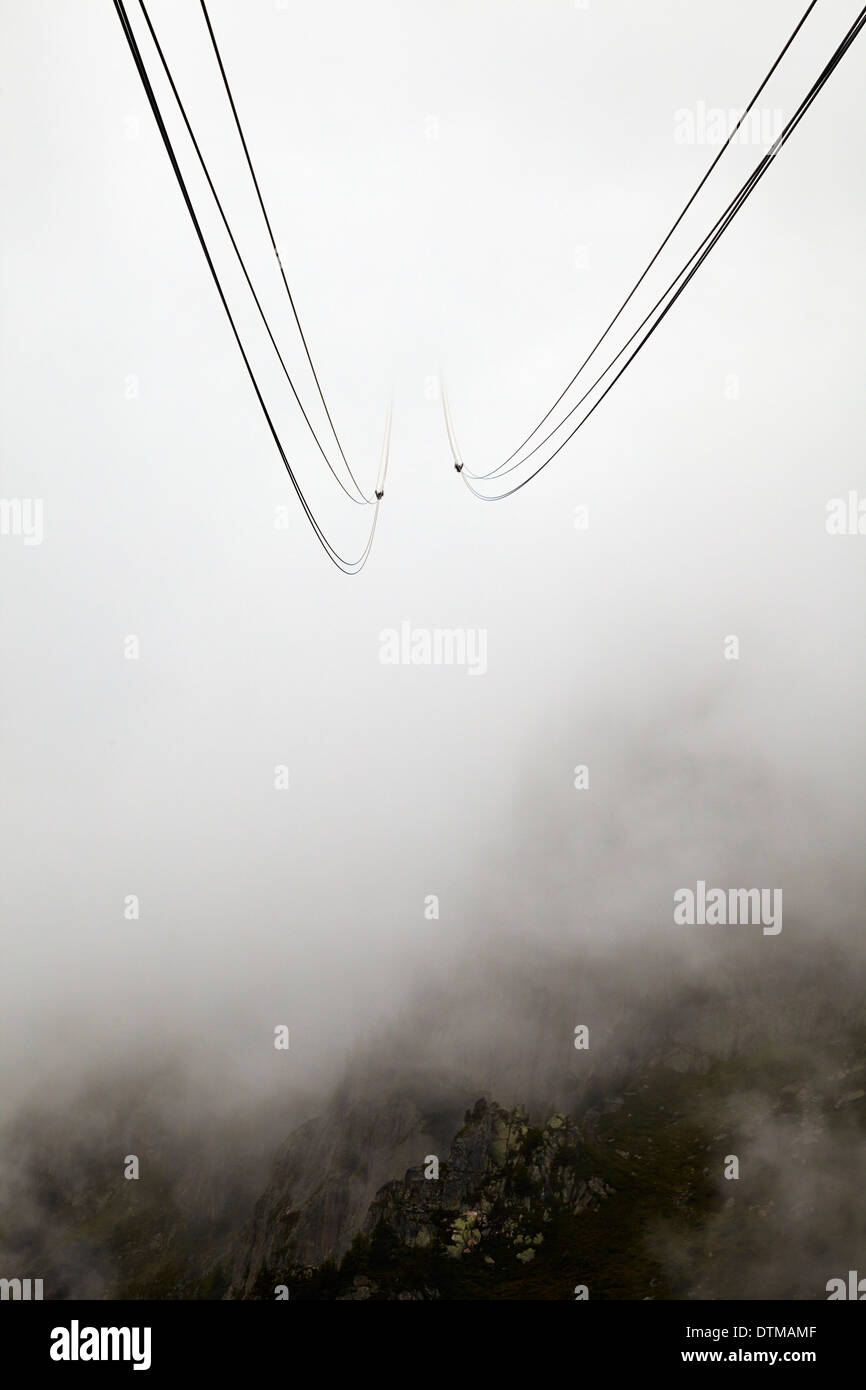Cablecar, or telepherique, cables disappearing into the mist from ...