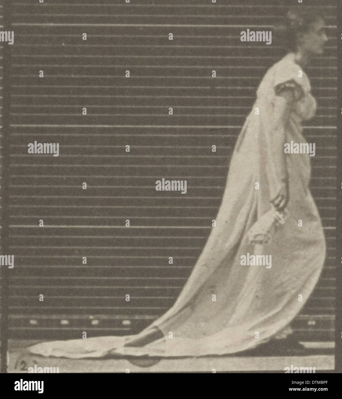 A woman in a long dress is shown stooping to lift a handkerchief ...