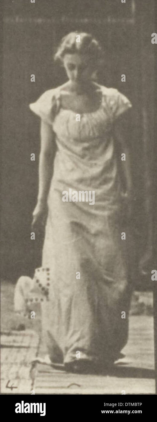 A woman in a long dress stooping down to lift a handkerchief, captured ...