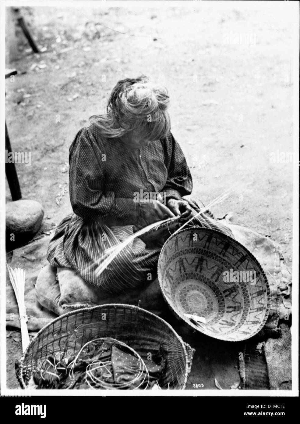 This photograph shows a Yokut Indian woman making baskets on the Tule ...