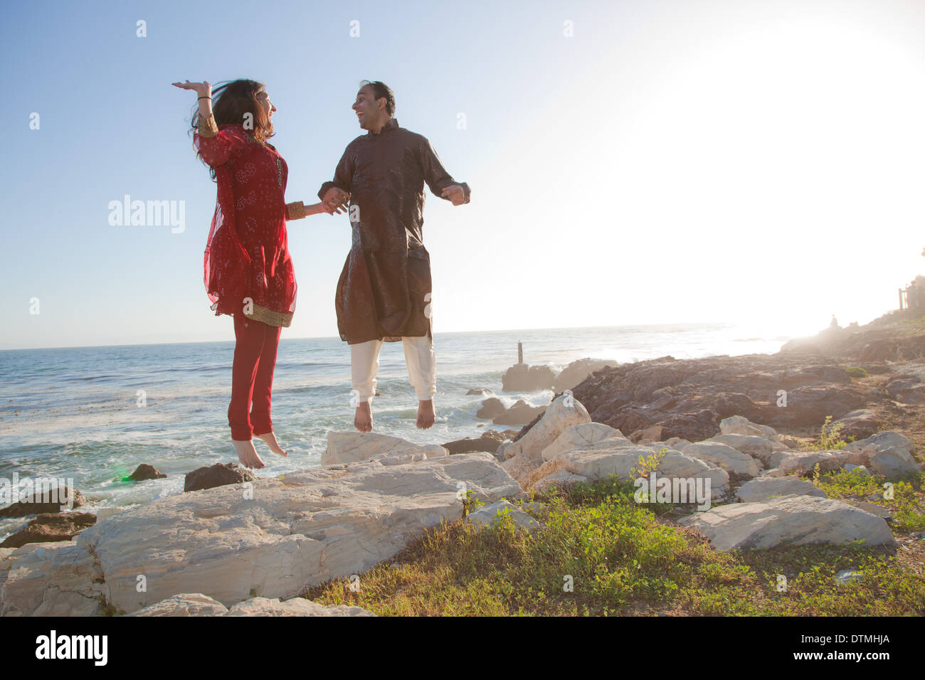 indian couple walk jump and hug each other beachside oceanside seaside ...