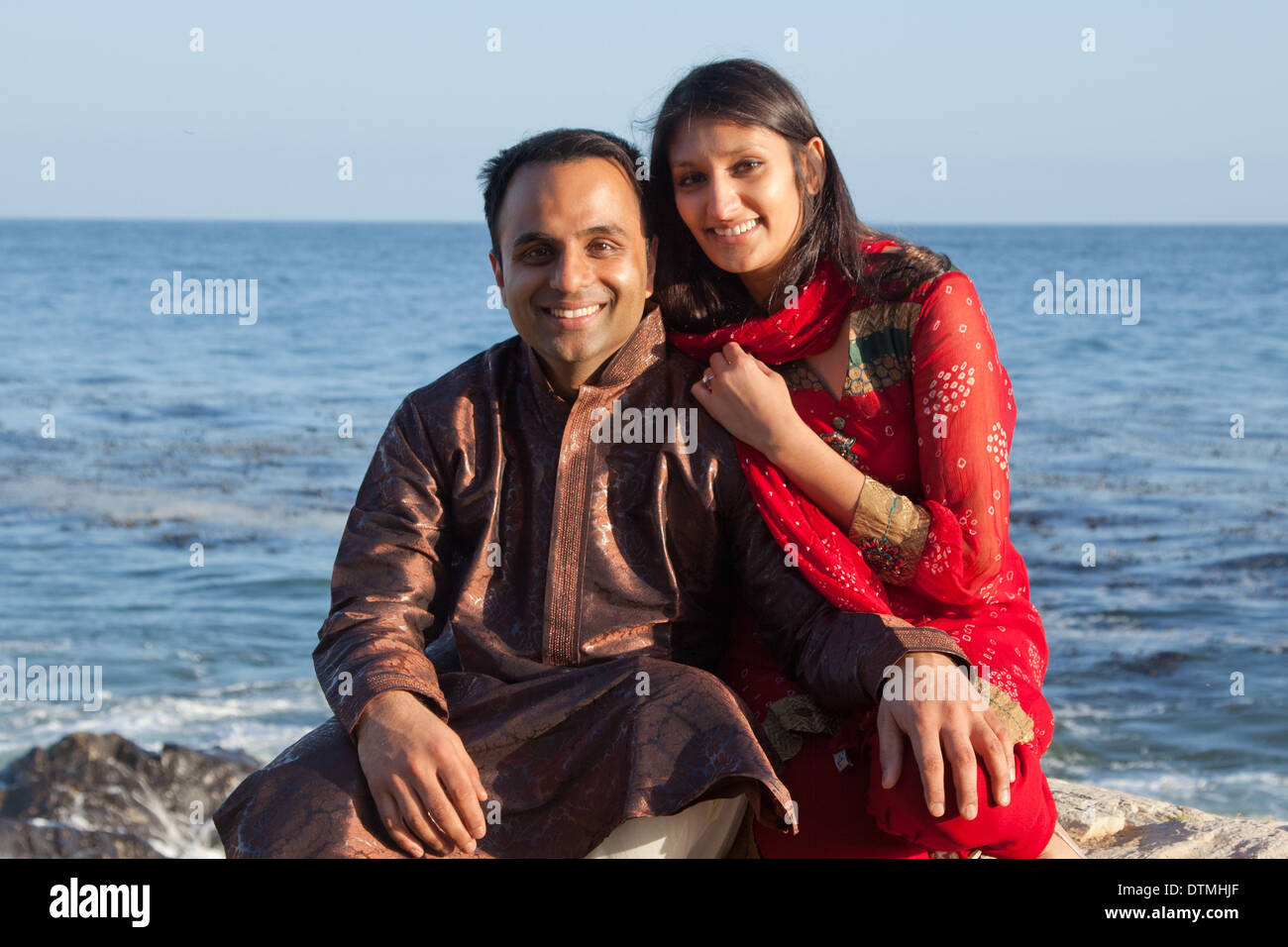 indian couple walk jump and hug each other beachside oceanside seaside ...