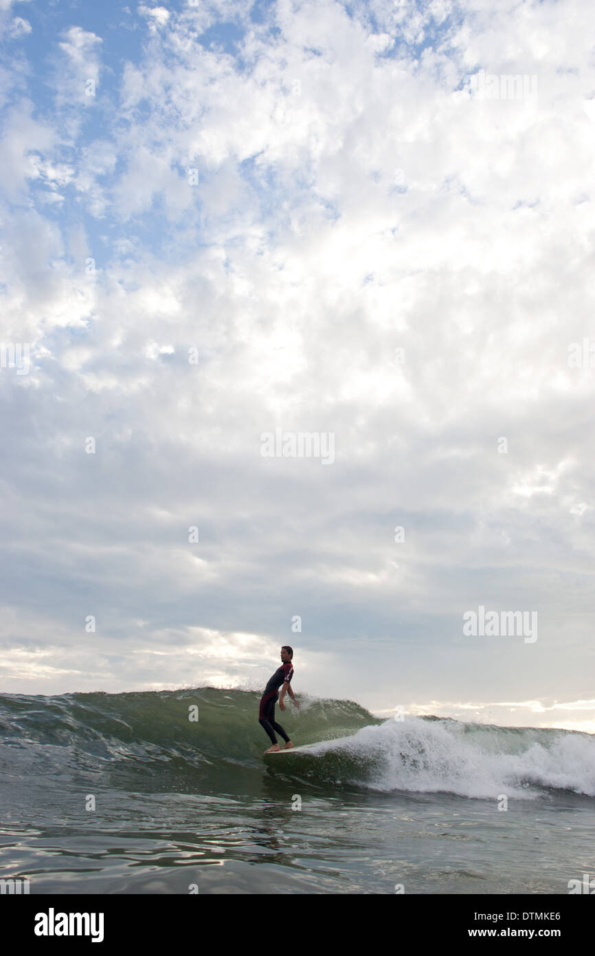 surfer surfing standing riding waves wave Stock Photo - Alamy