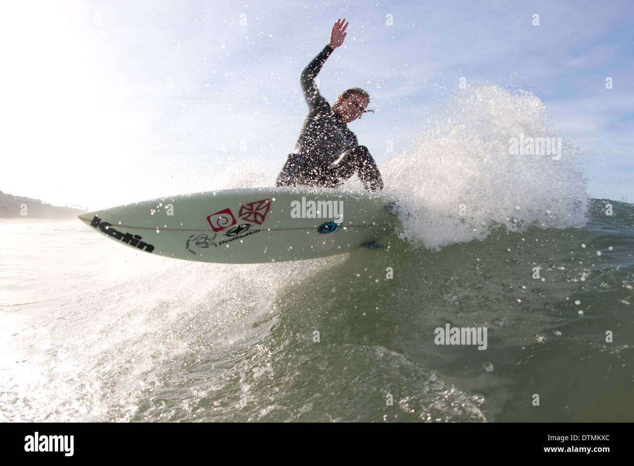 surfer riding a wave in hawaii with one hand up Stock Photo - Alamy