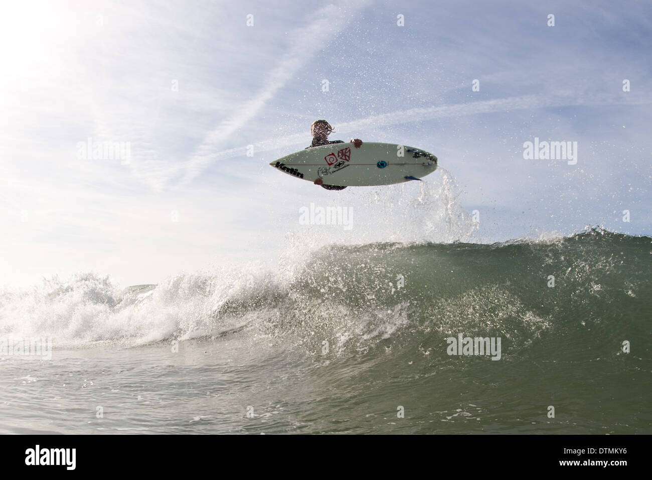 surfing cathcing some air while jumping and holding his surfboard in ...