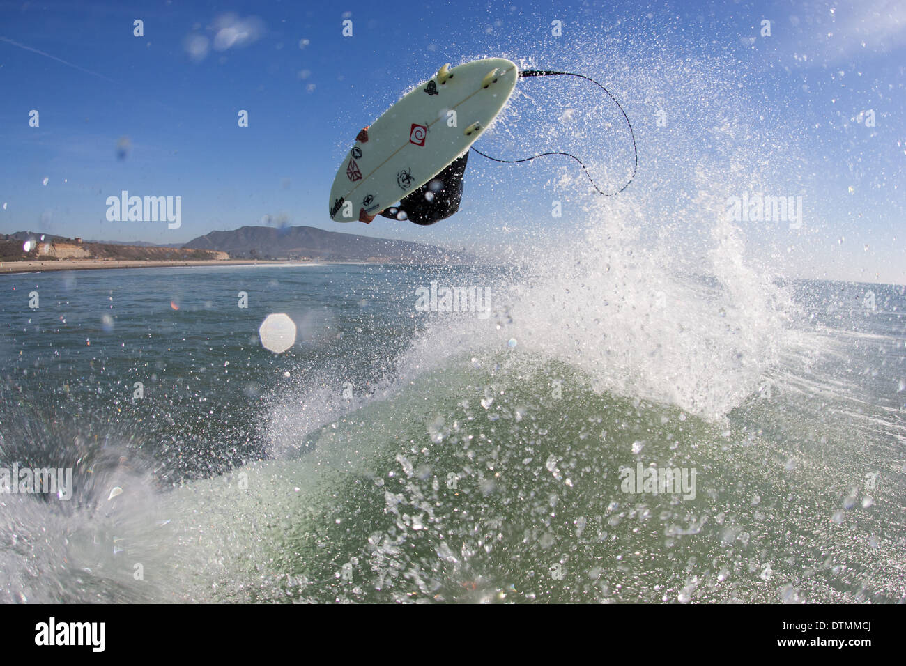 surfer splashes and catches some air in the ocean while holding his ...