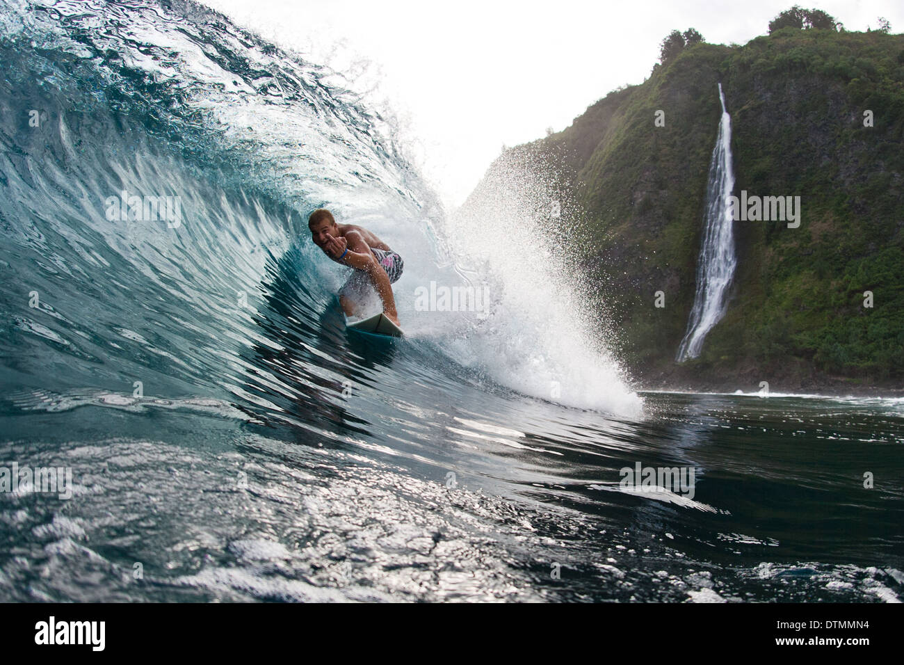 hawaii waterfall and surfer in barrel of water wave ocean sea giving ...