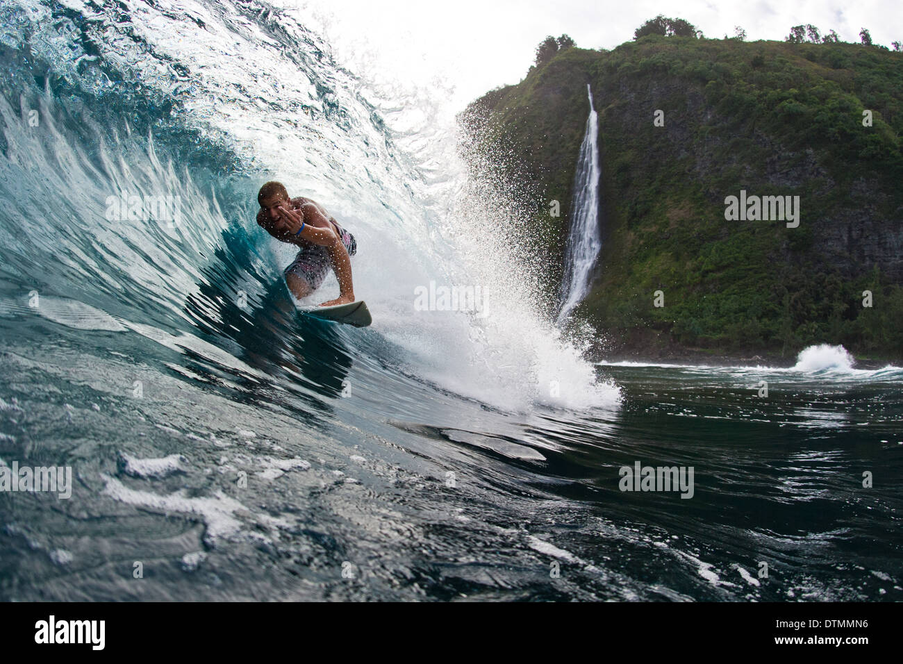 hawaii waterfall and surfer in barrel of water wave ocean sea giving ...