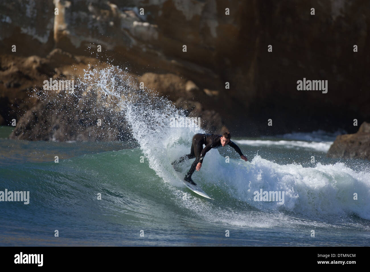surfer whips his surfboard in the ocean sea water with some tricks in a ...