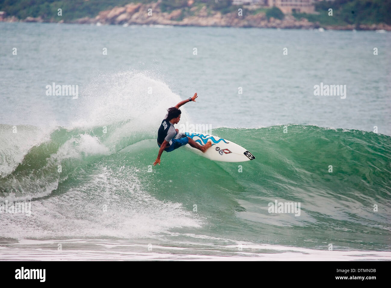 surfer whips his surfboard in the ocean sea water with some tricks in a ...