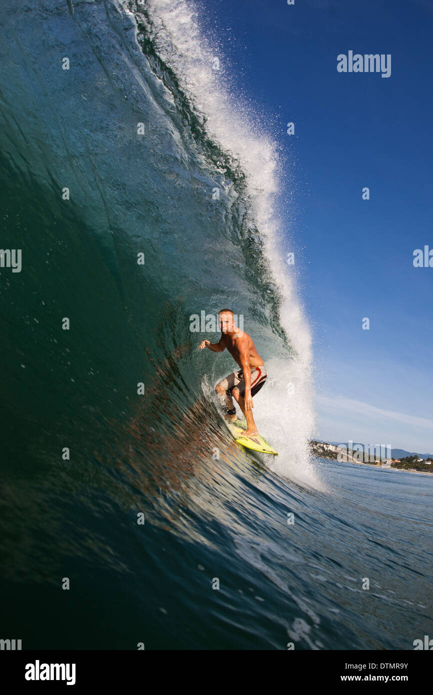 surfer inside the barrel of a wave on his surfboard in the ocean sea ...