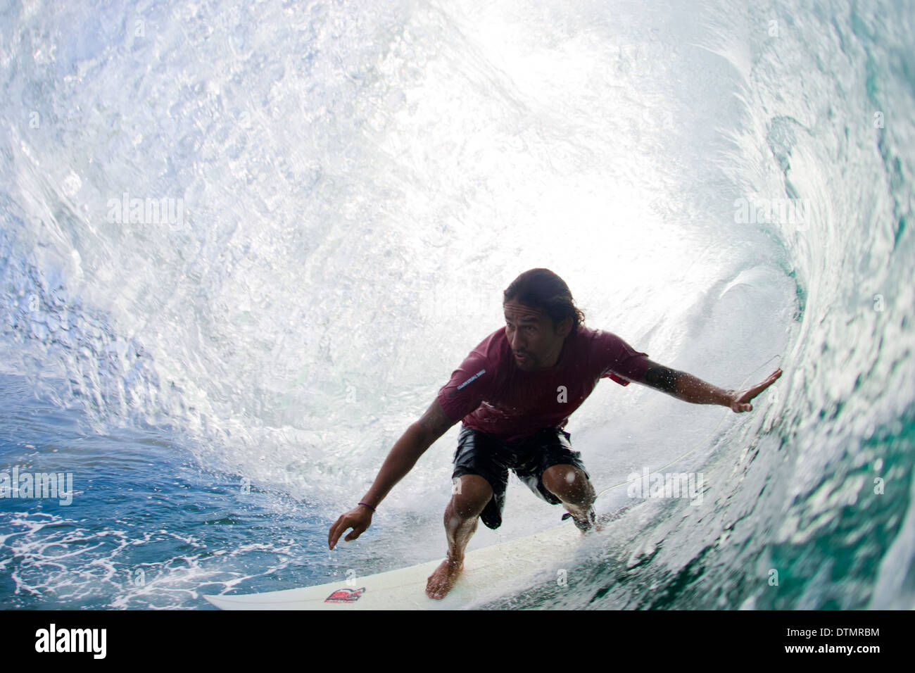 surfer inside the barrel of a wave on his surfboard in the ocean sea ...