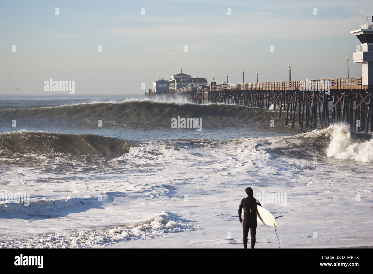 large waves at the beach while bystanders look on and watch the ocean ...