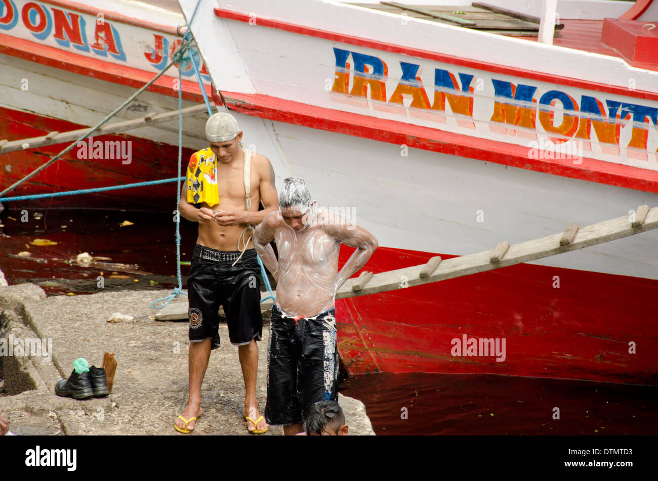 Brazil, Amazon, Manaus. Busy waterfront pier. Local workers bathing in ...